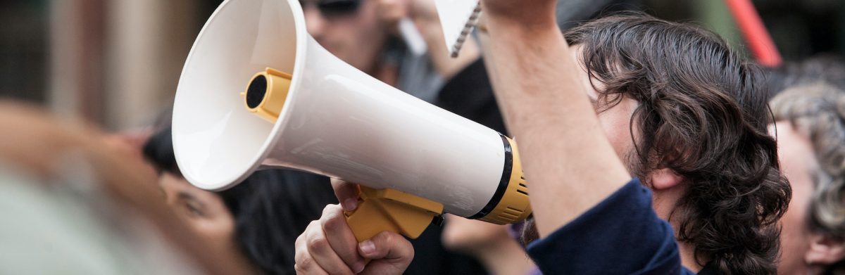demostrator with megaphone and notebook protesting | Second Street Lab